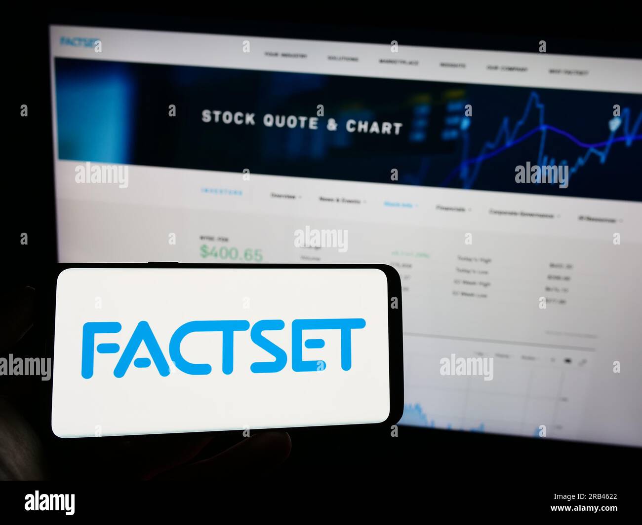 Person holding mobile phone with logo of American company FactSet ...
