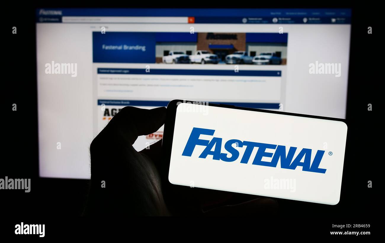 Person holding cellphone with logo of US distribution business Fastenal ...