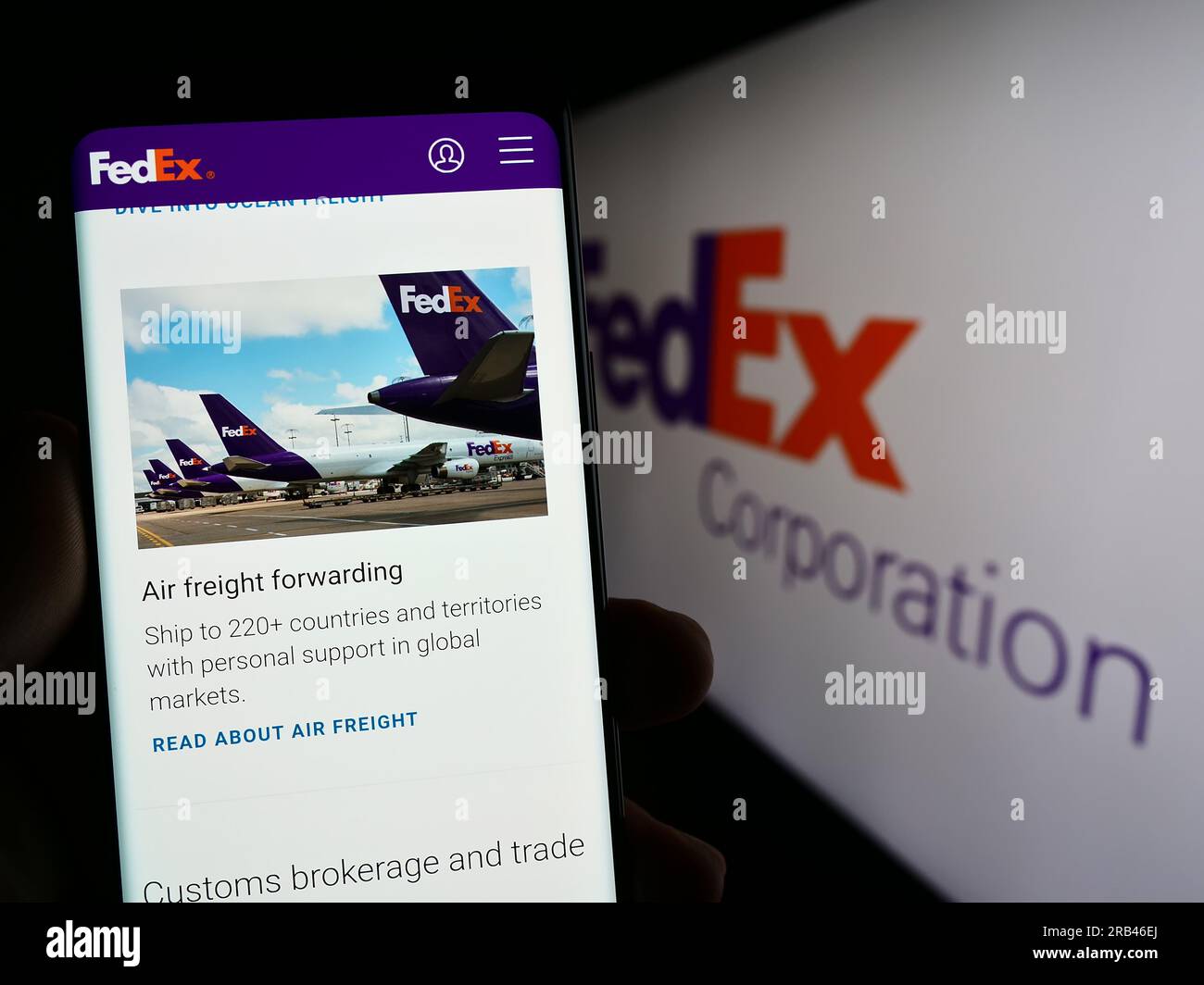 Person holding smartphone with web page of US logistics company FedEx ...