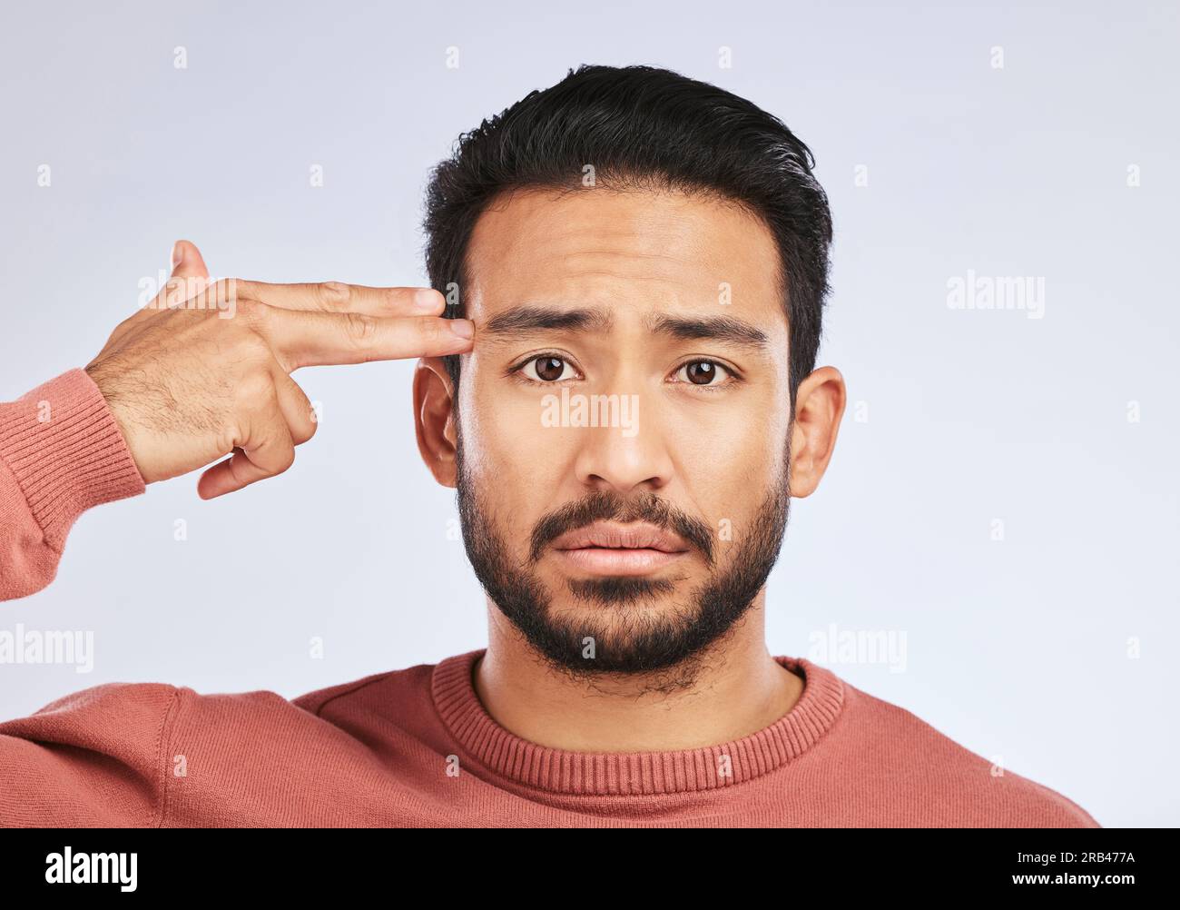 Depression, portrait and sad asian man with hand gun in studio for ...