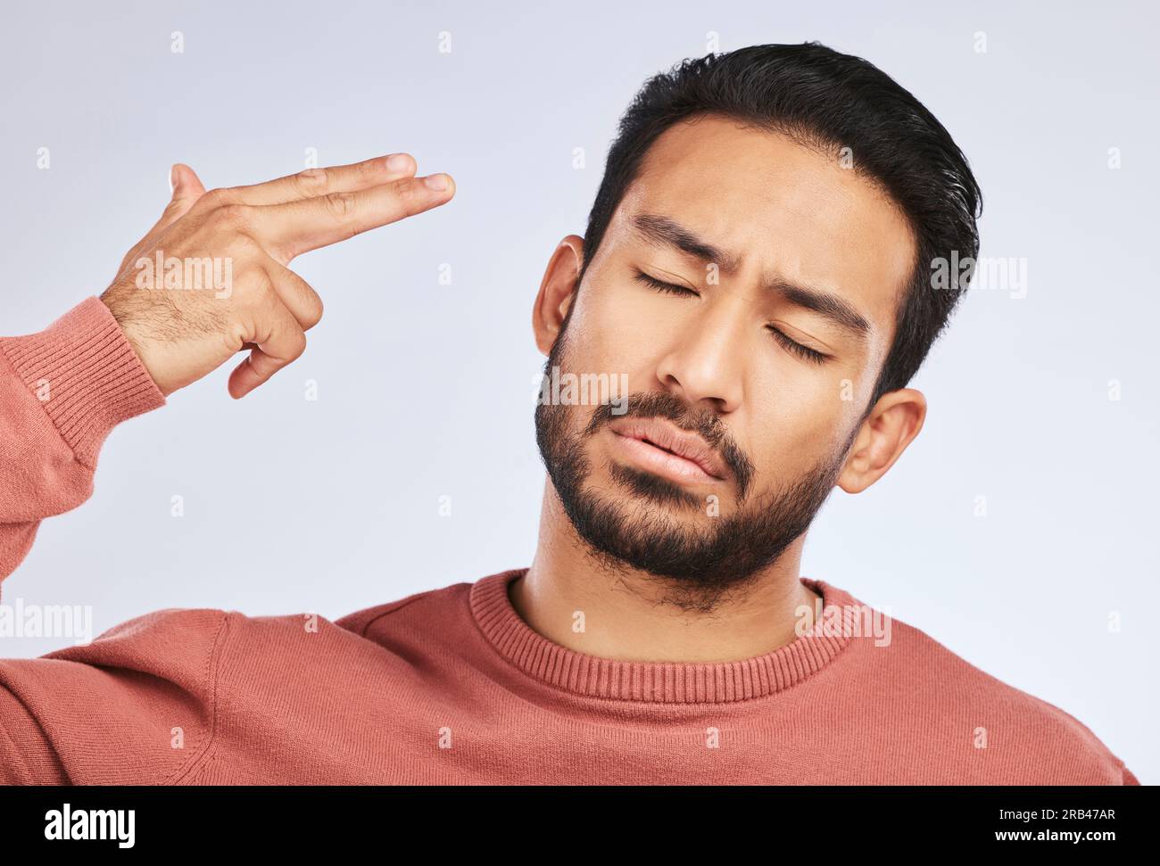 Depression, face and asian man with hand gun in studio for anxiety ...
