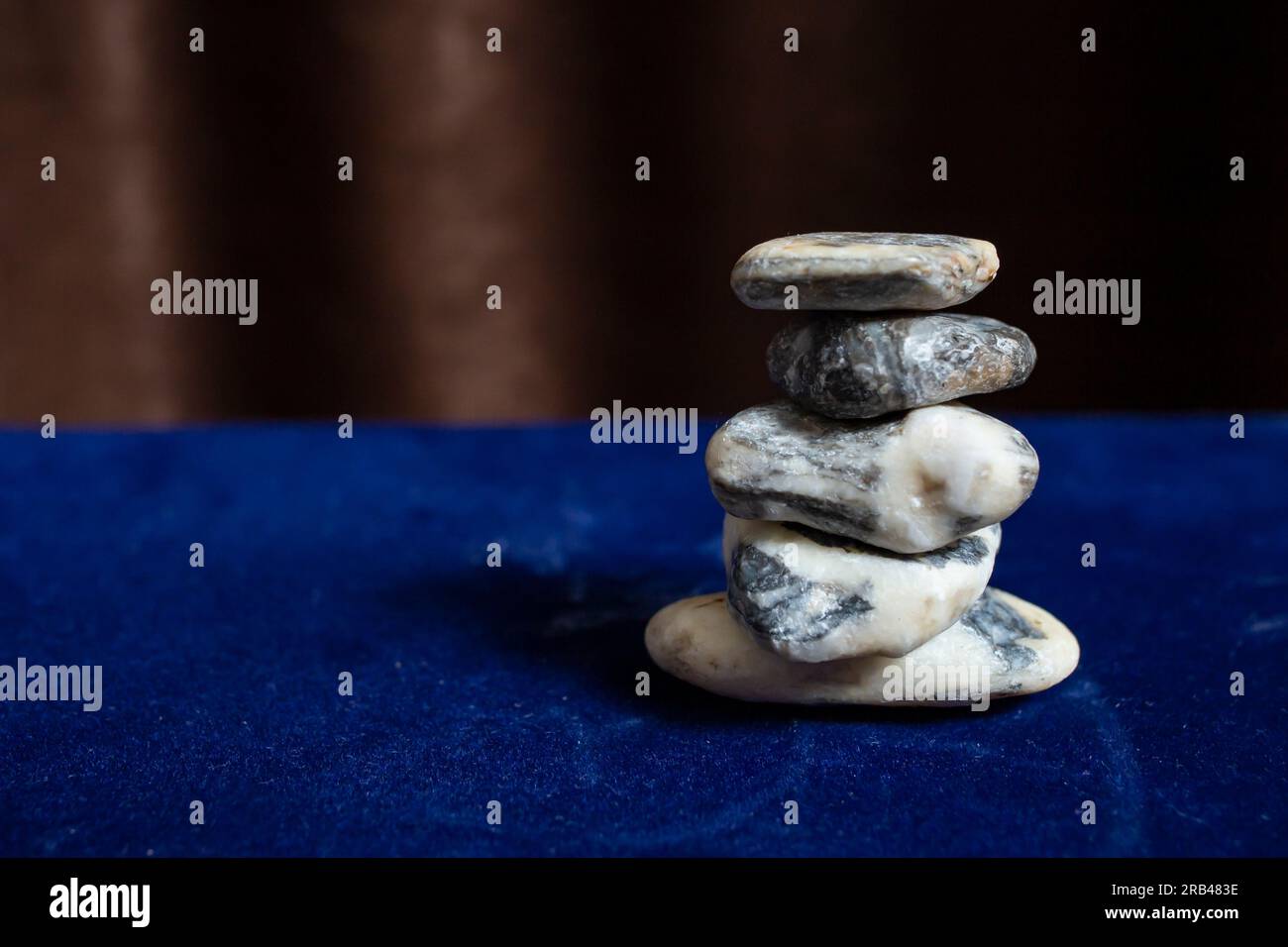 White stones stack on blue velvet and brown courtains, serene zen ...