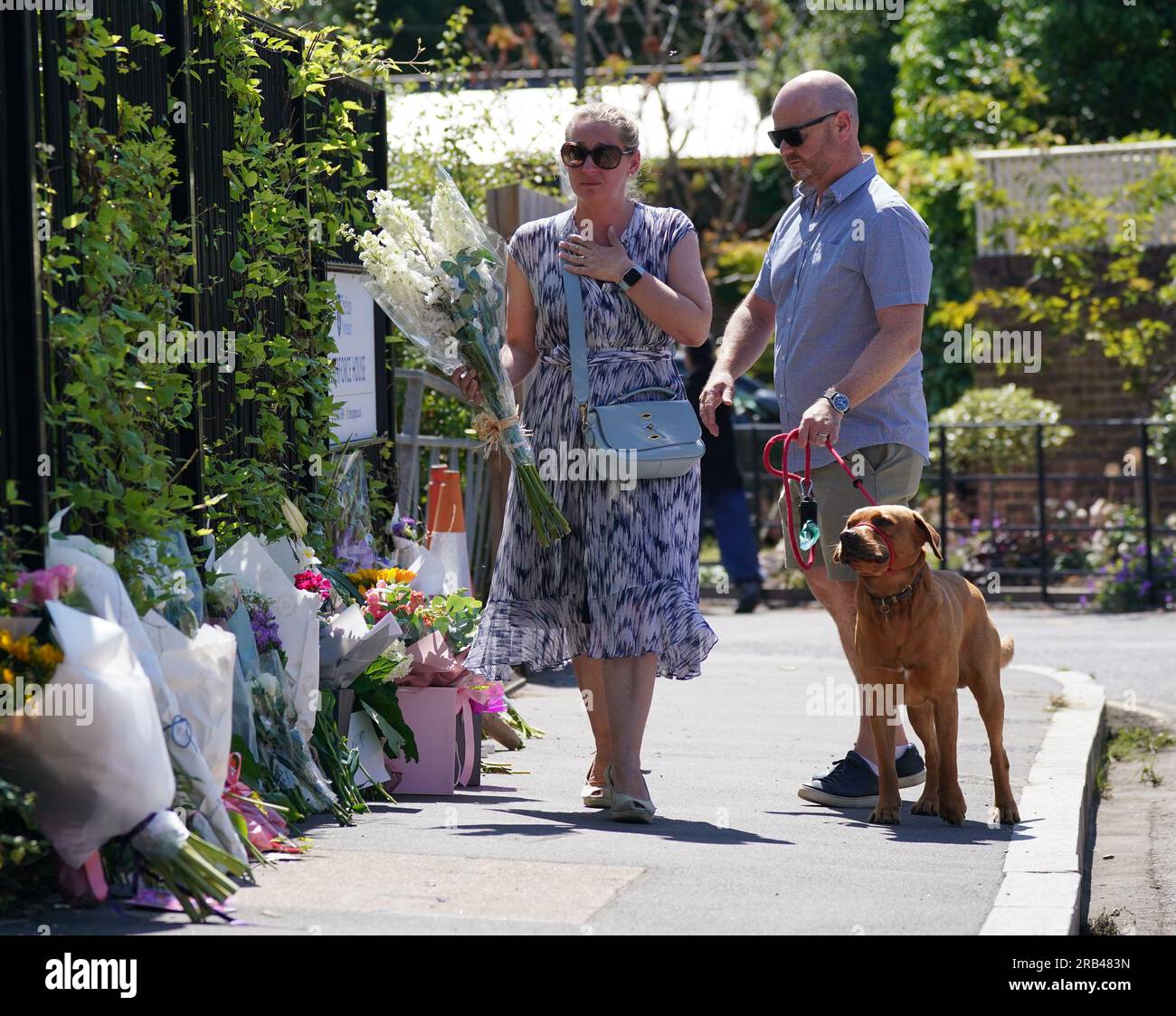 A woman bringing flowers in tribute outside the Study Preparatory ...