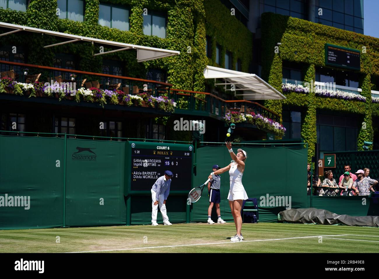Alicia Barnett serves during their Ladies Doubles match with Olivia ...