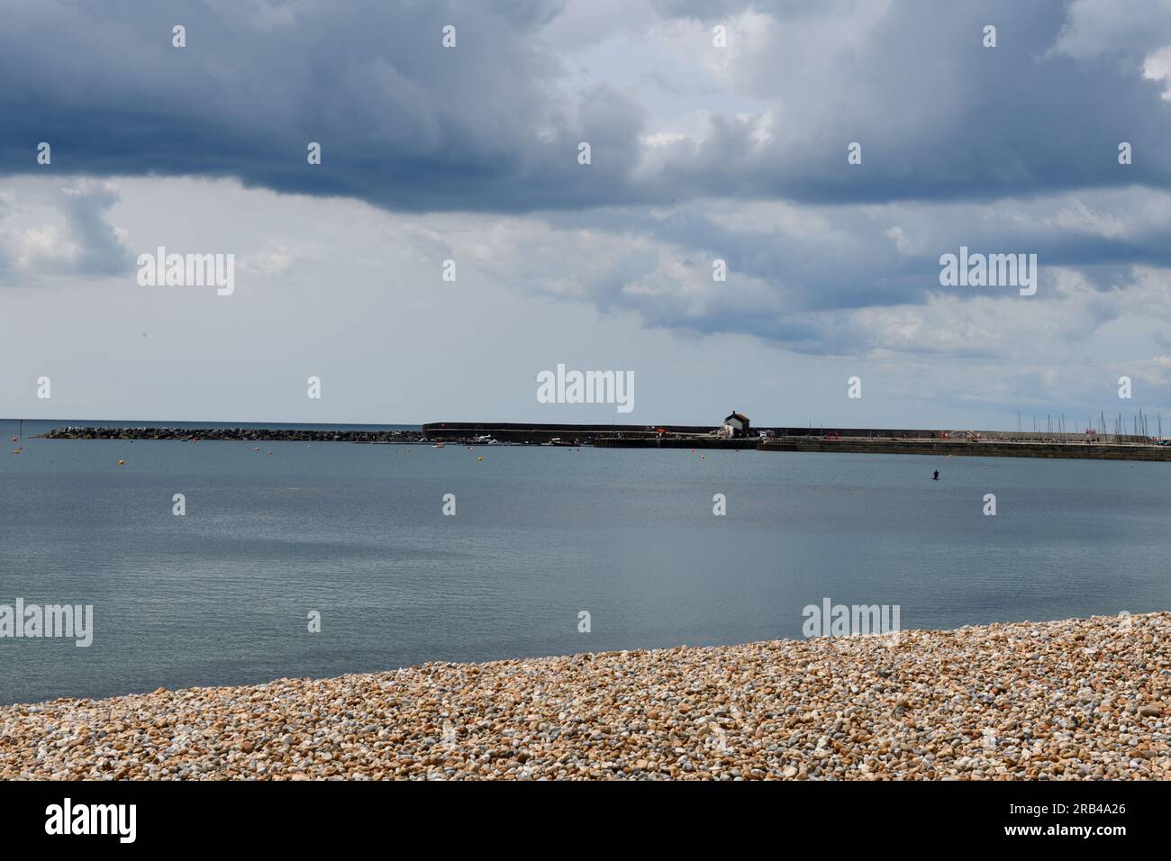 Lyme Bay with Harbour Wall and Paddle Boarder at Lyme Regis Dorset ...