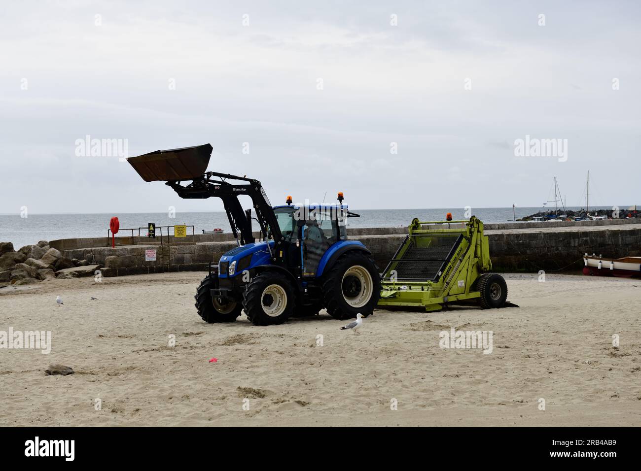 Tractor pulling the Barber Surf Rake to level the Sand and clean the ...