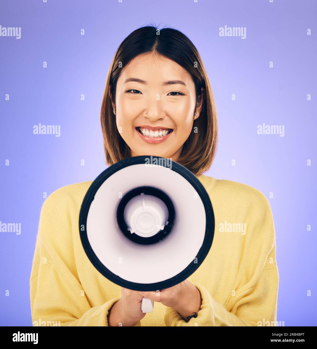 Woman, megaphone and happy portrait in studio for announcement, voice or broadcast. Face of a ...