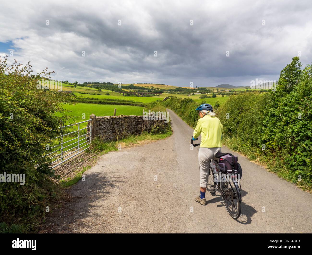 A woman cycling towards the Lowgill viaduct in the Lune Valley in the ...