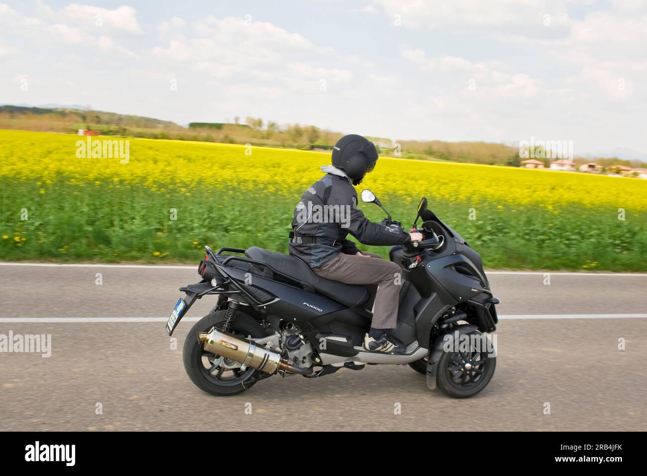 Young man driving a scooter Stock Photo - Alamy
