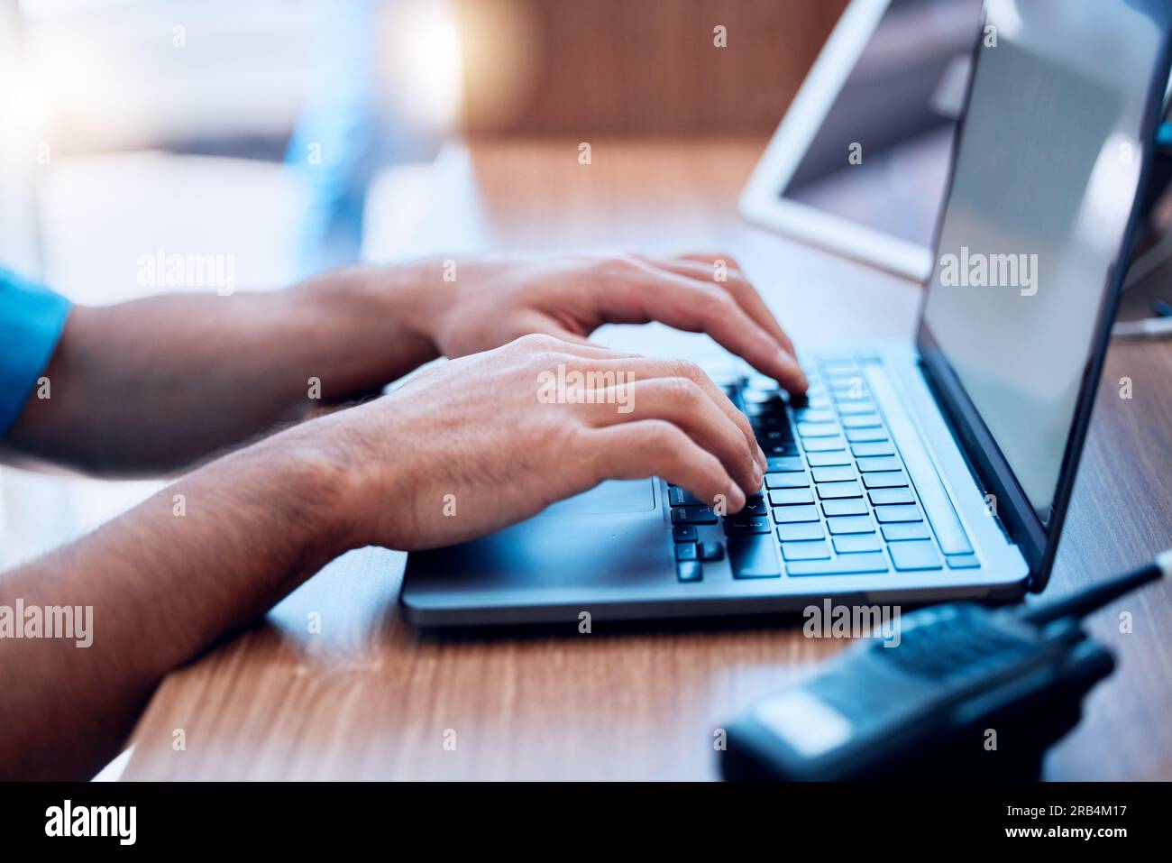 Laptop, radio and hands of security typing or writing an investigation ...