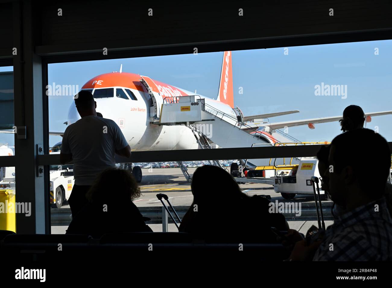 Airport boarding area with passengers in silhouette waiting to fly ...