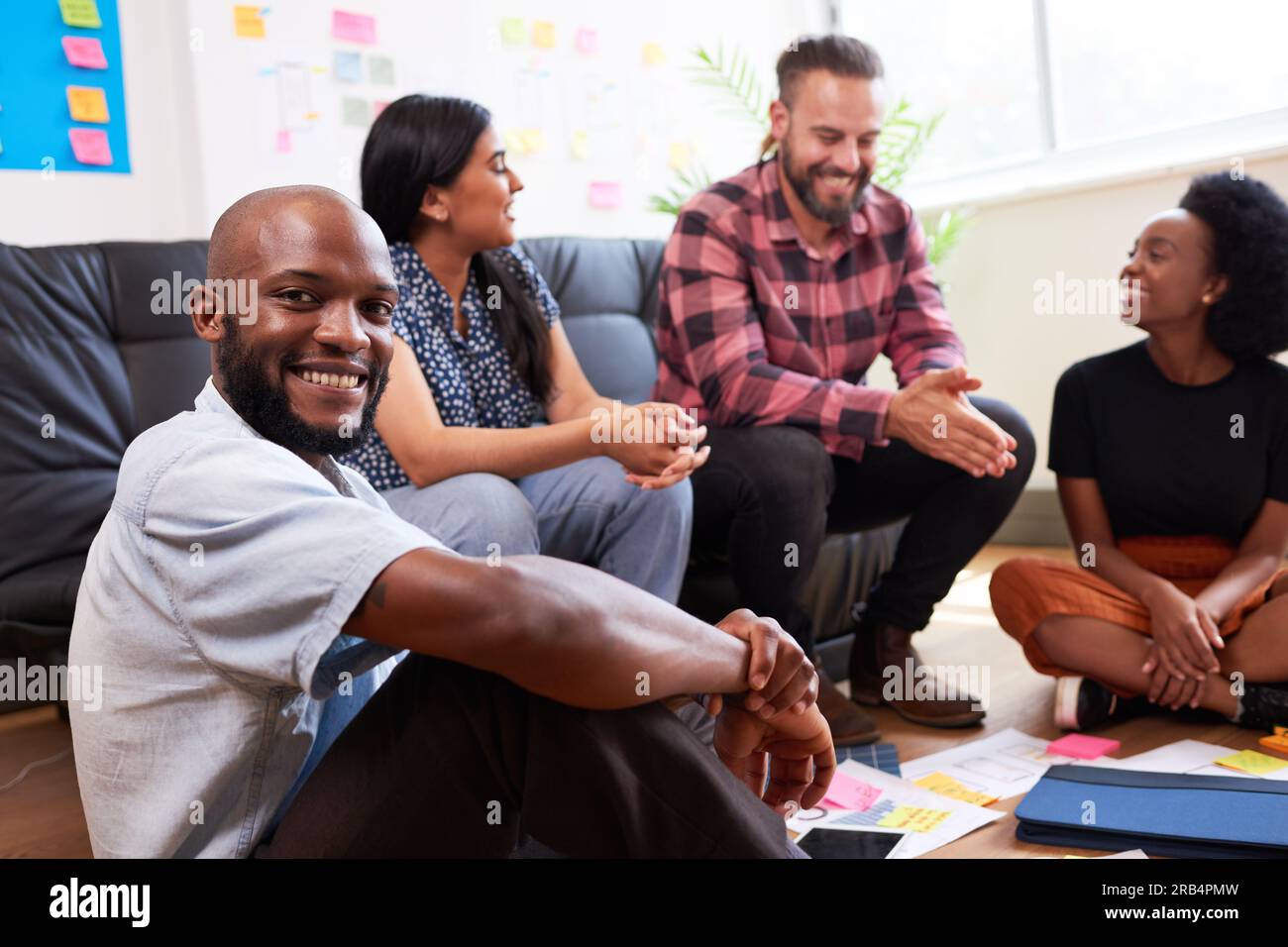 Group of diverse colleagues brainstorm together, informal meeting sit ...