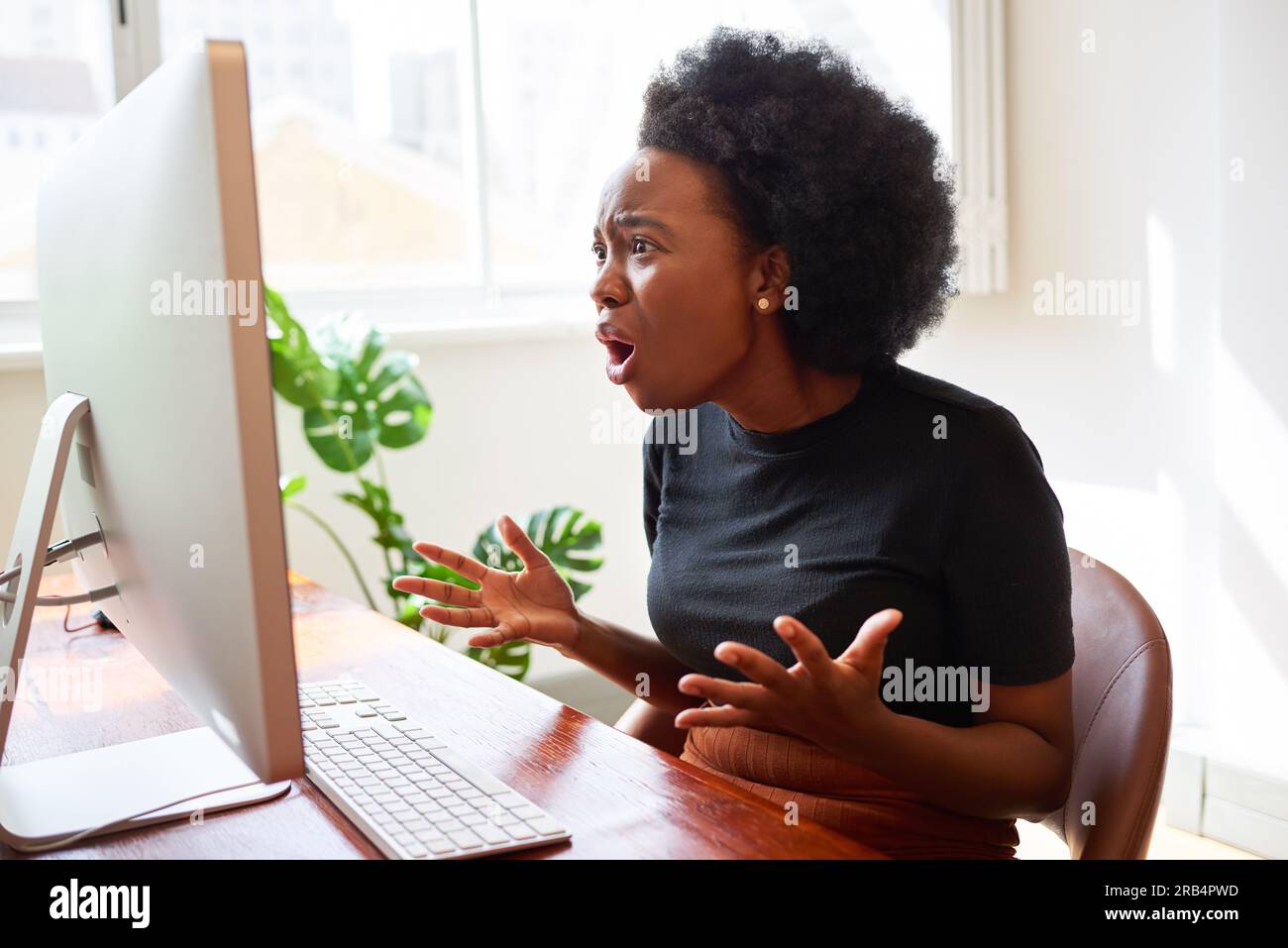 Frustrated and upset young developer shouts at screen, Black woman in ...