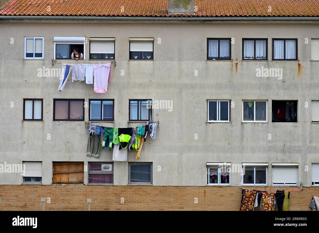 Block of older flats by beach with laundry hanging out to dry below ...