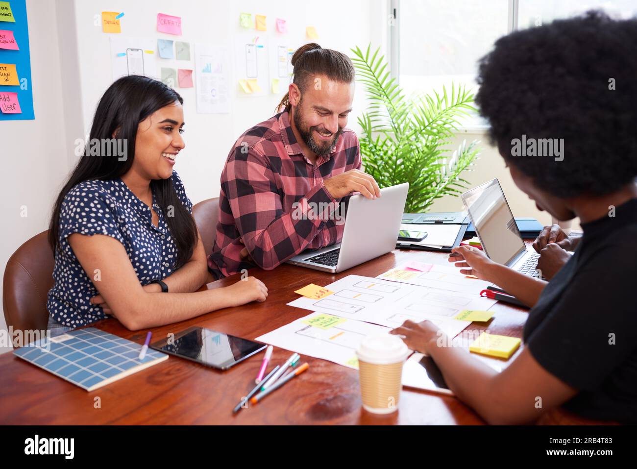 Team of developers review mockup design of new app around boardroom ...