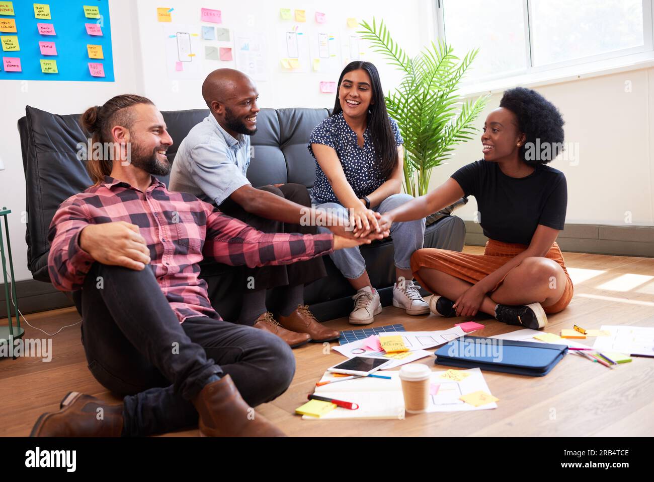 Multiracial group of colleagues put hands together in stack, celebrate ...