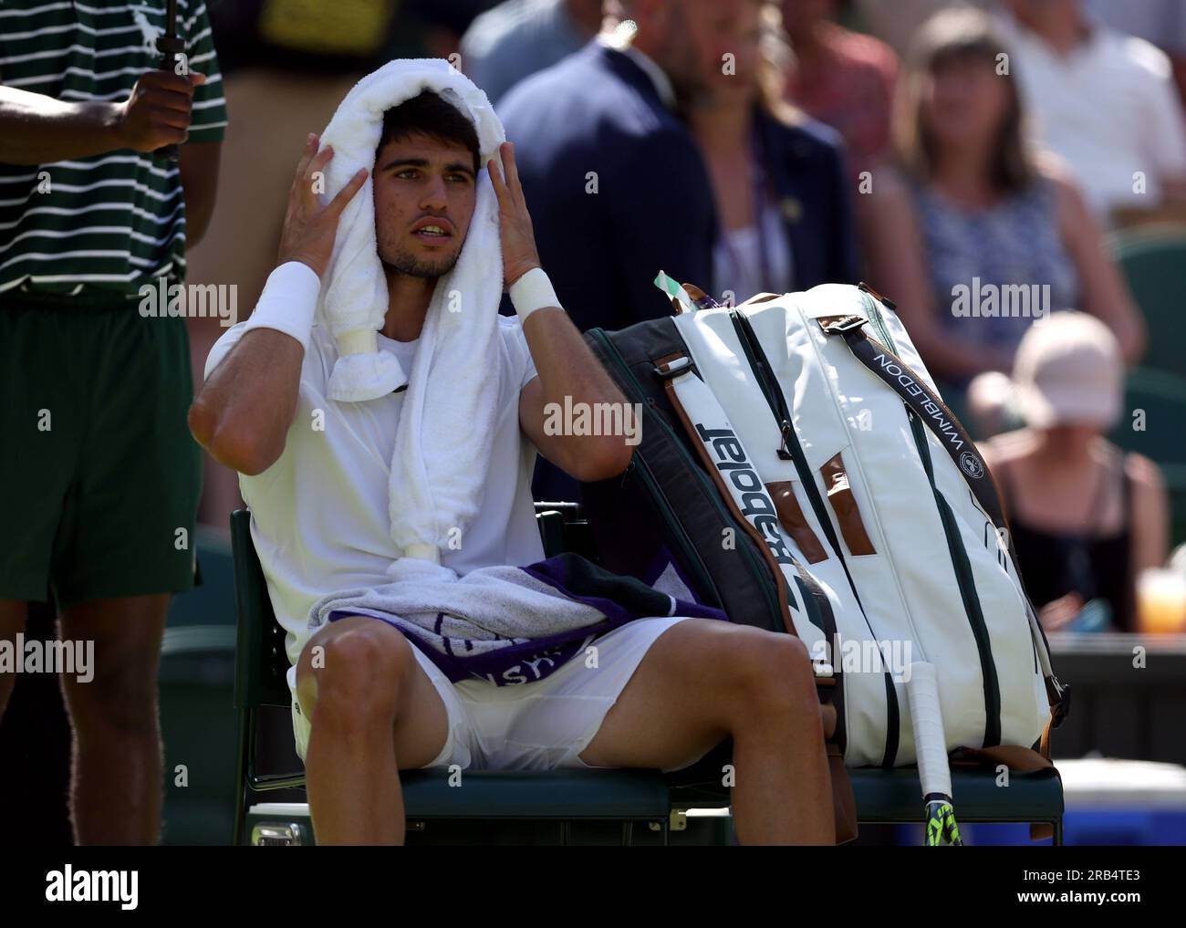 Carlos Alcaraz uses a towel filled with ice to try and cool down during ...