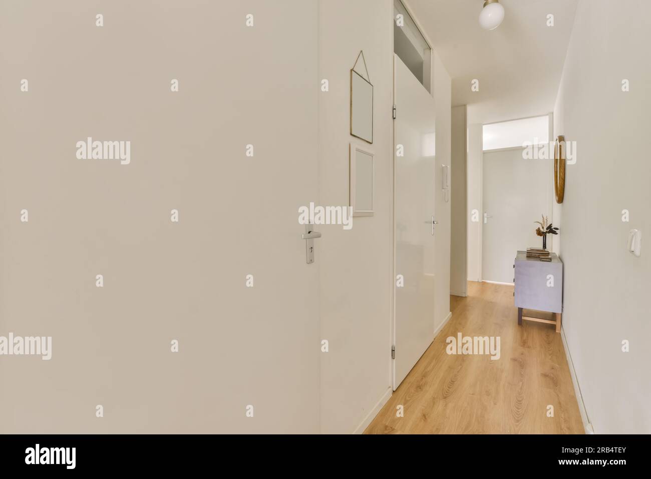an empty hallway with white walls and wood flooring the room is well ...