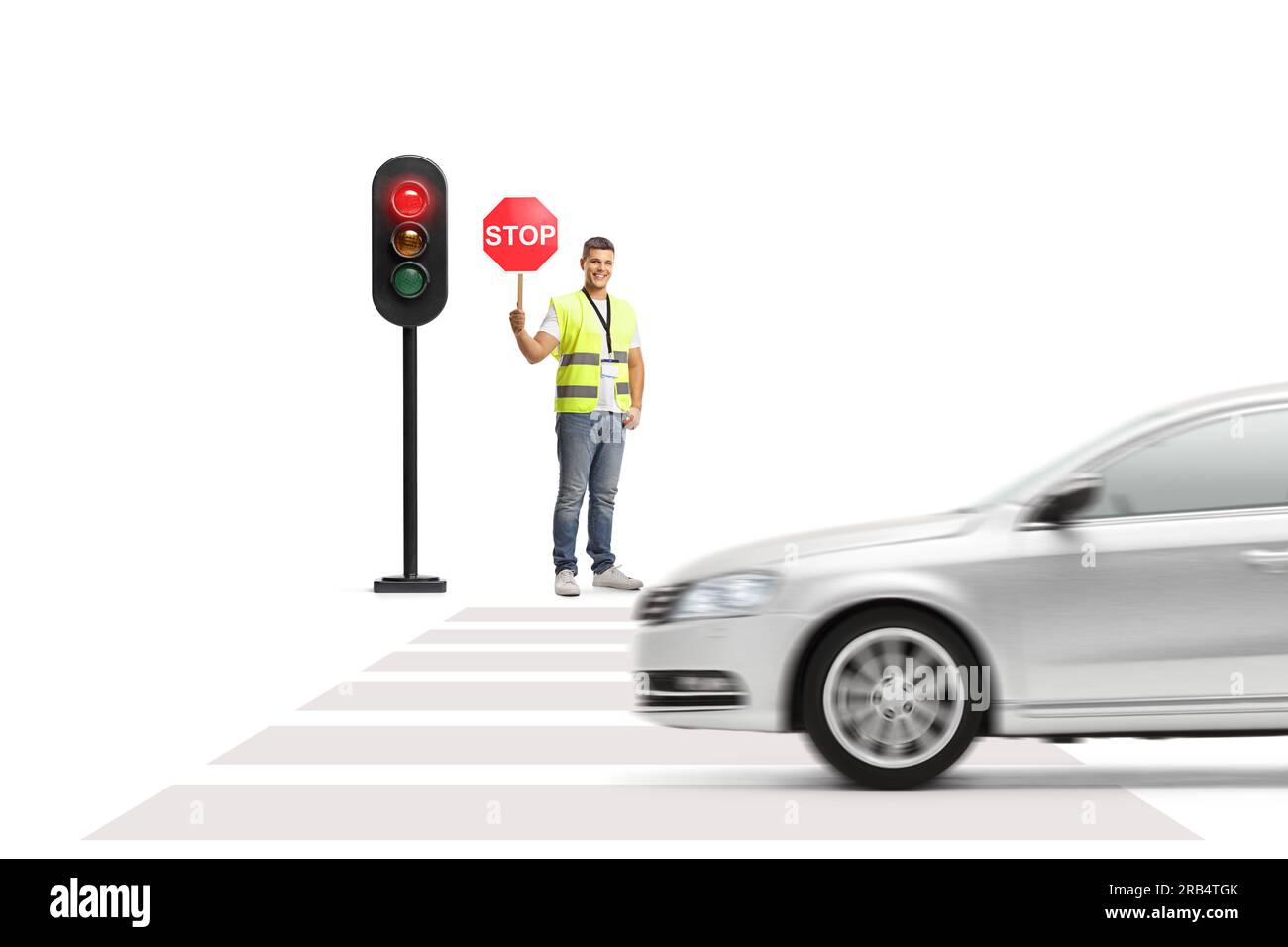Young man in a safety vest with a stop sign waiting at traffic lights ...