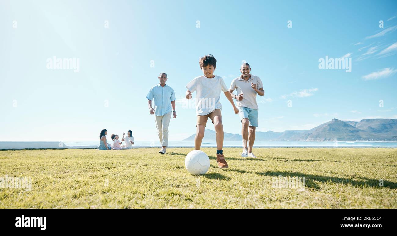 Family, soccer and men with ball in a park for fun, playing and bonding ...