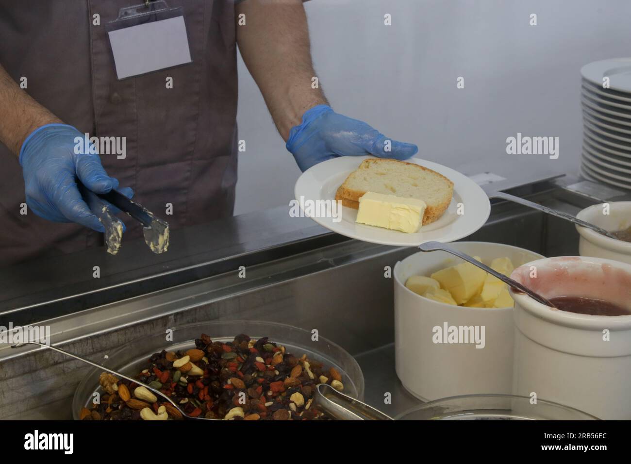 Buffet style service - Canteen worker at serving line putting food on ...