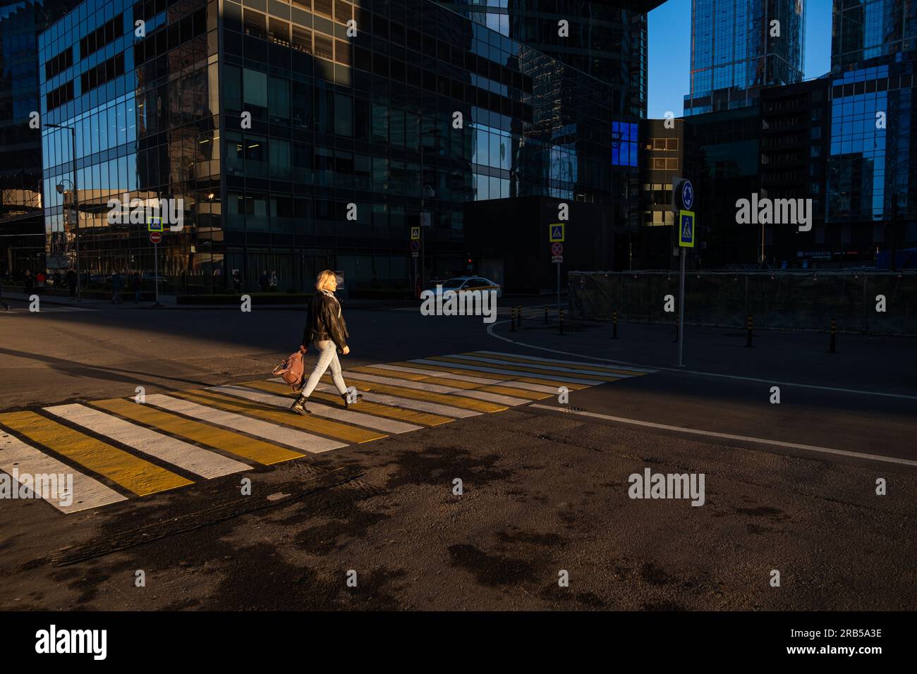 stylish woman crossing road on zebra while walking outdoors Stock Photo ...