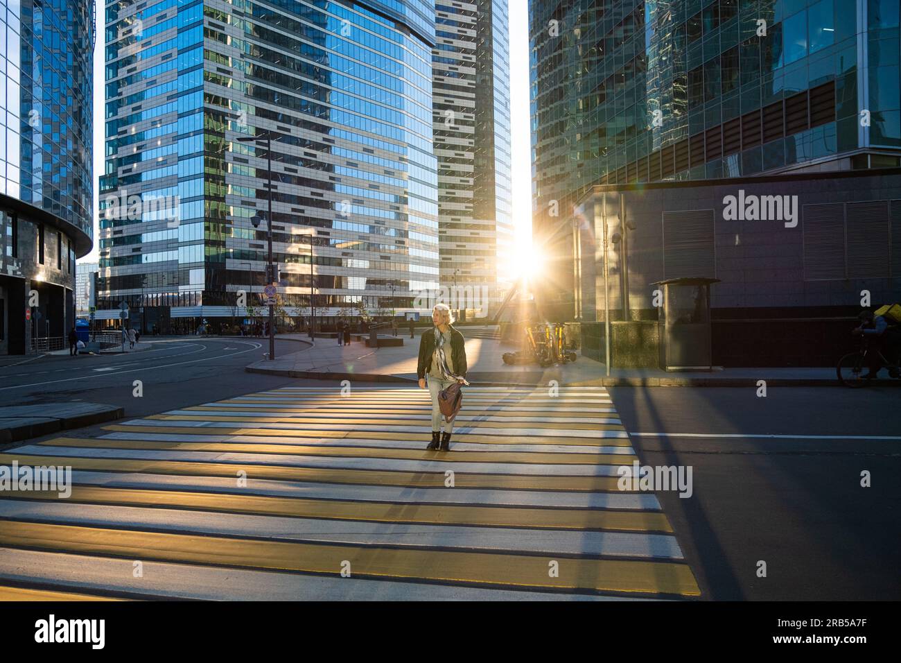 stylish woman crossing road on zebra while walking outdoors Stock Photo ...
