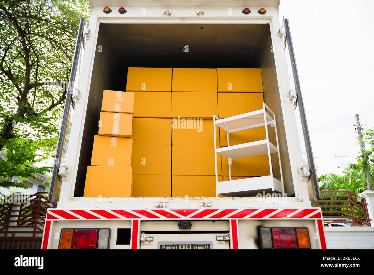 Cardboard boxes in car trunk, Delivery employees working with cardboard ...