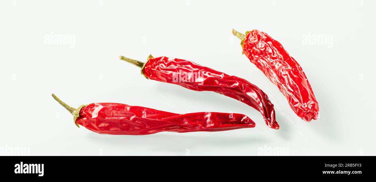 Three pods of hot red pepper on a white background Stock Photo - Alamy