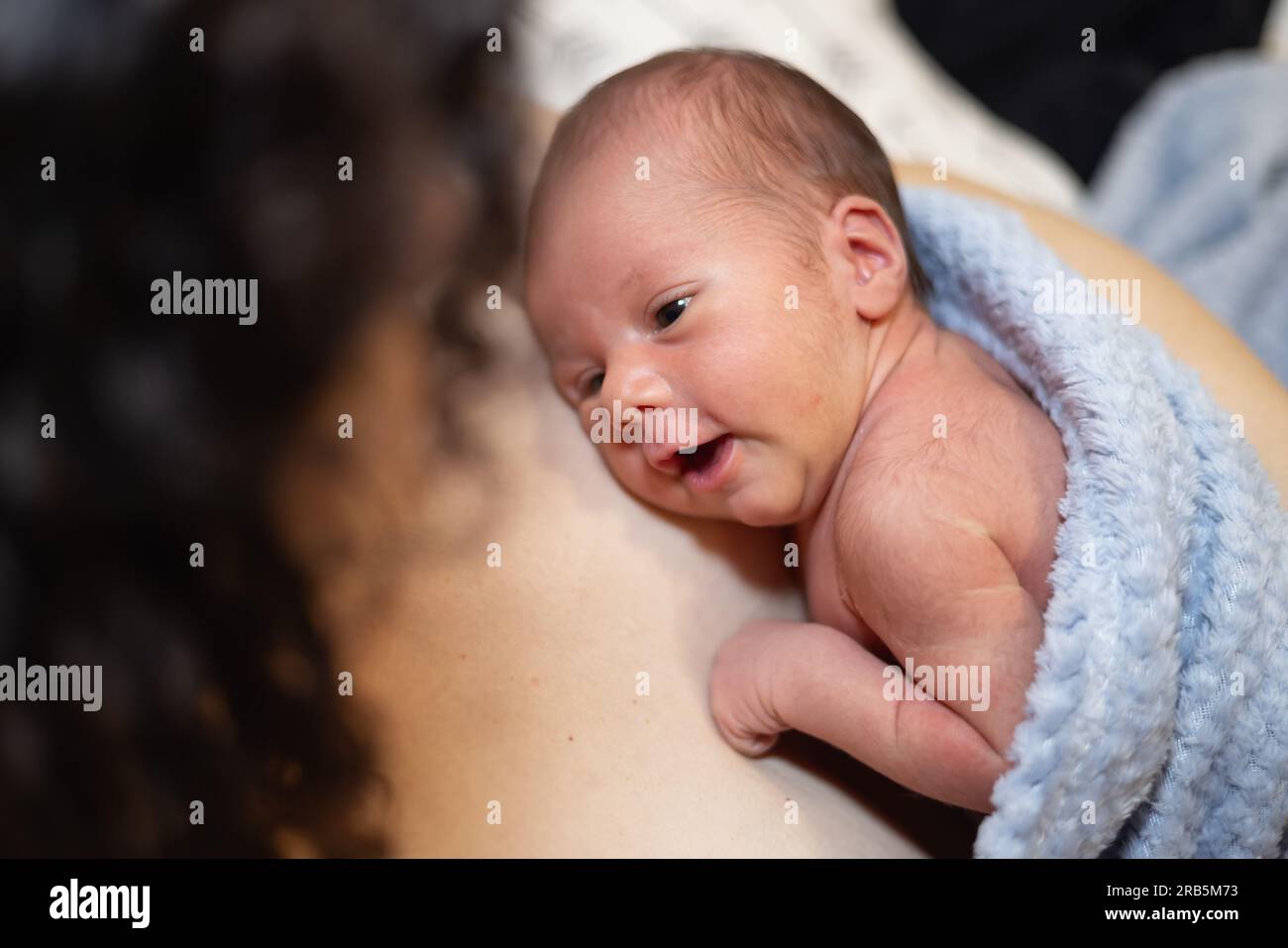 Adorable Newborn Baby Boy sitting on mother chest Stock Photo - Alamy