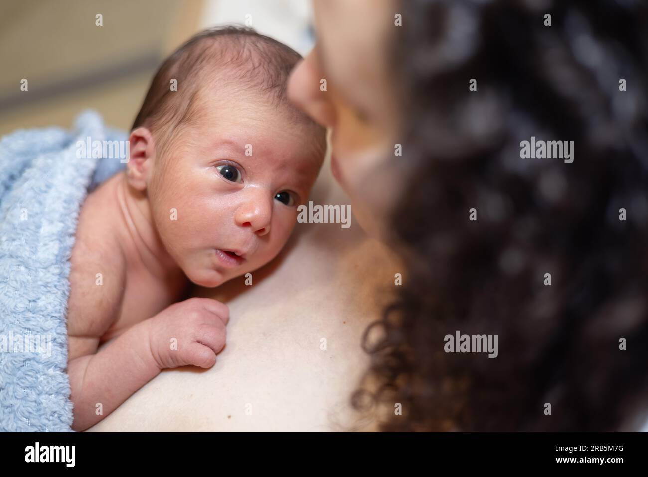 Adorable Newborn Baby Boy sitting on mother chest Stock Photo - Alamy