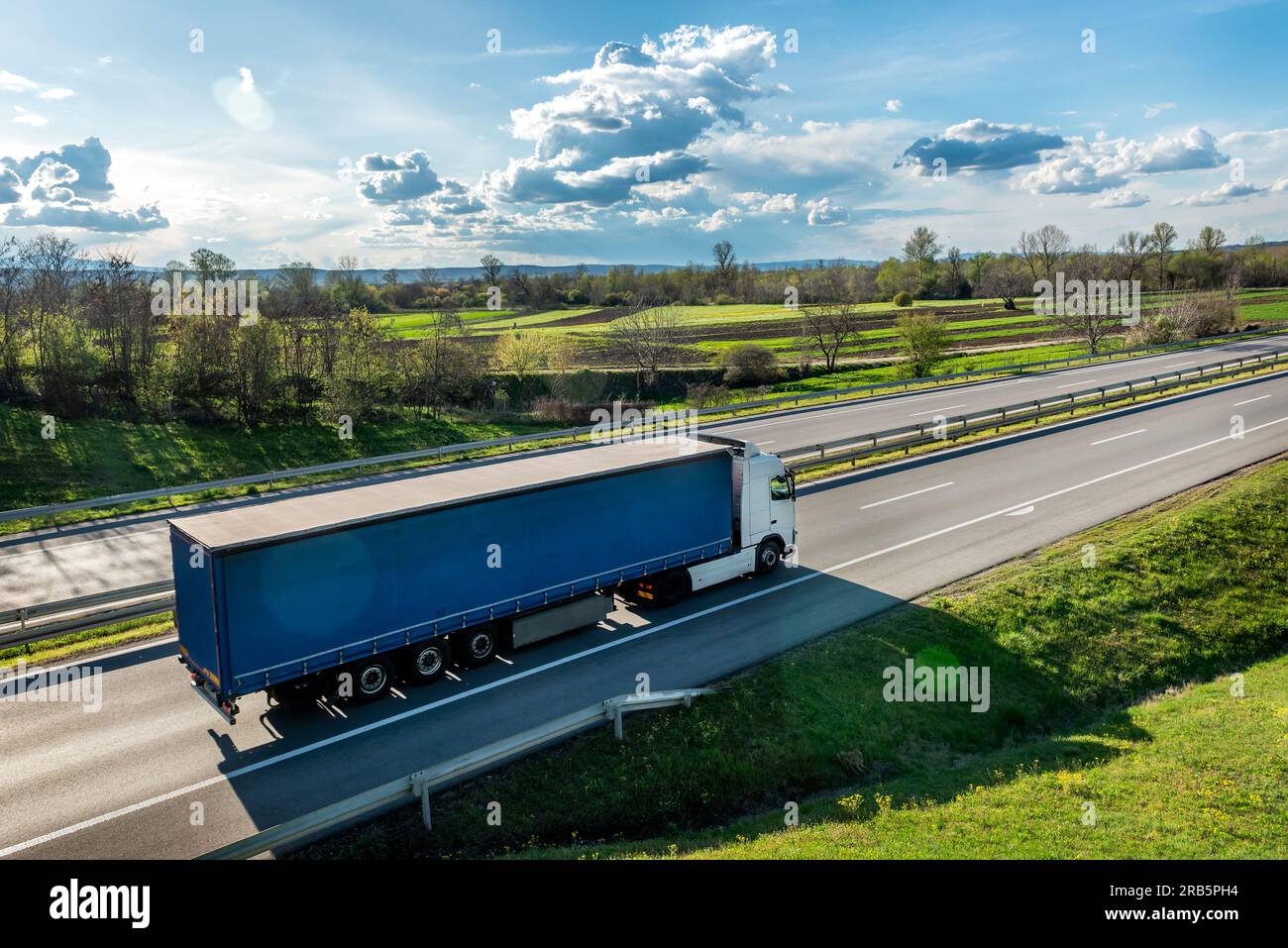 Large Transportation Truck on a highway road through the countryside ...