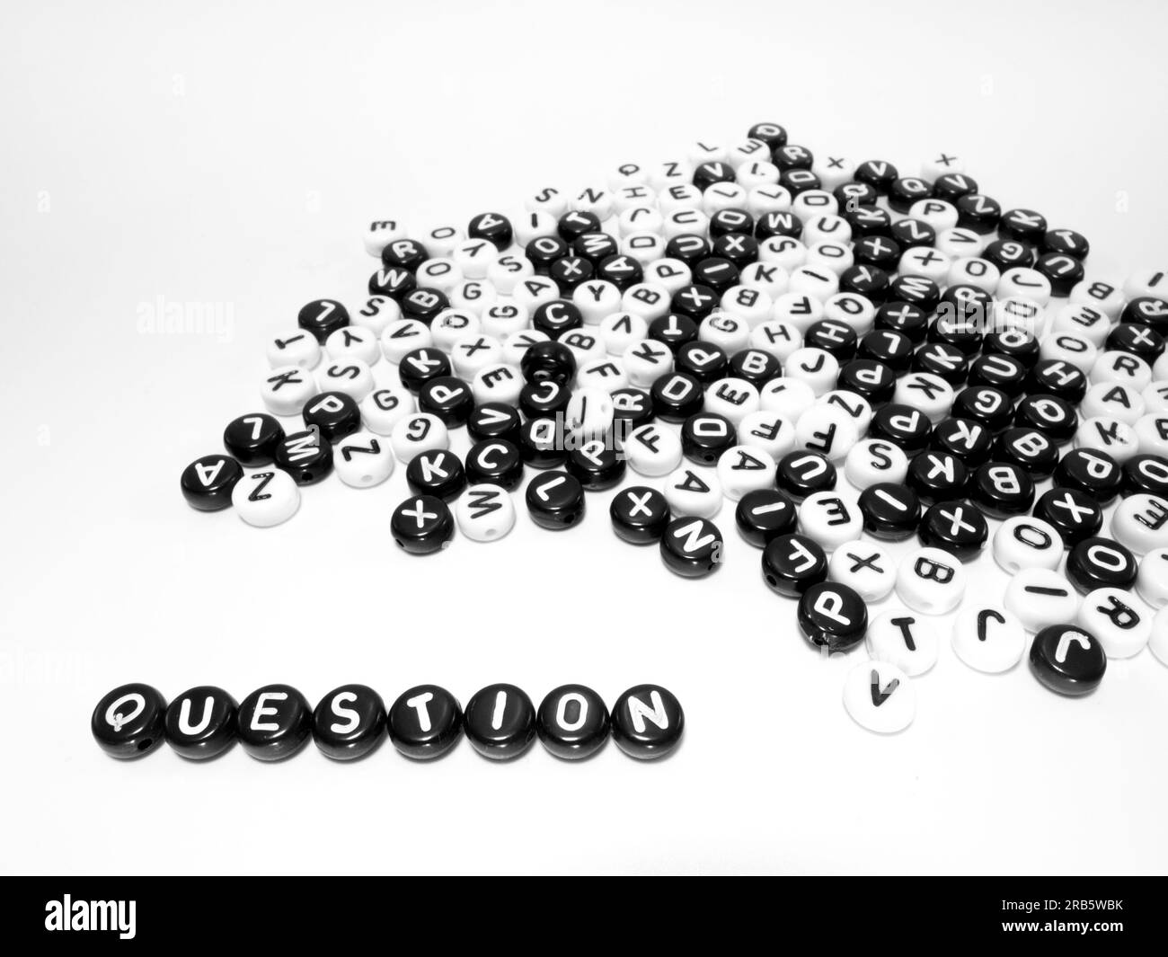 Heap of round letters black and white and question word written by side ...