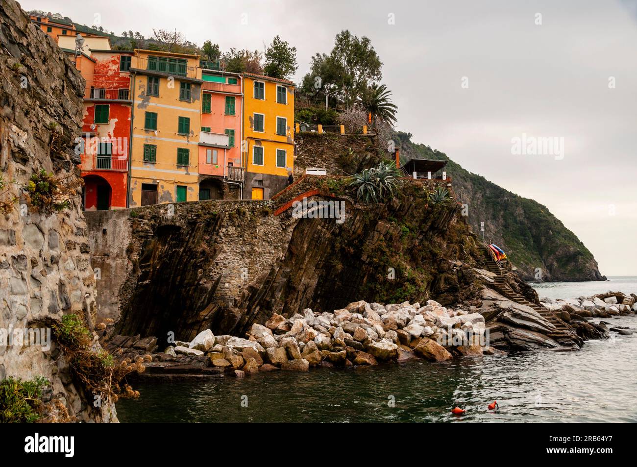 Colorful tower houses, kayaks and stone stairways in Riomaggiore, a ...