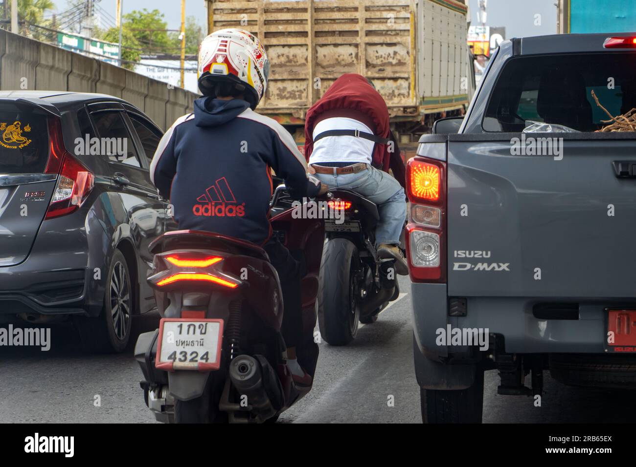 BANGKOK, THAILAND, JUNE 03 2023, A motorcyclist driving through narrow ...
