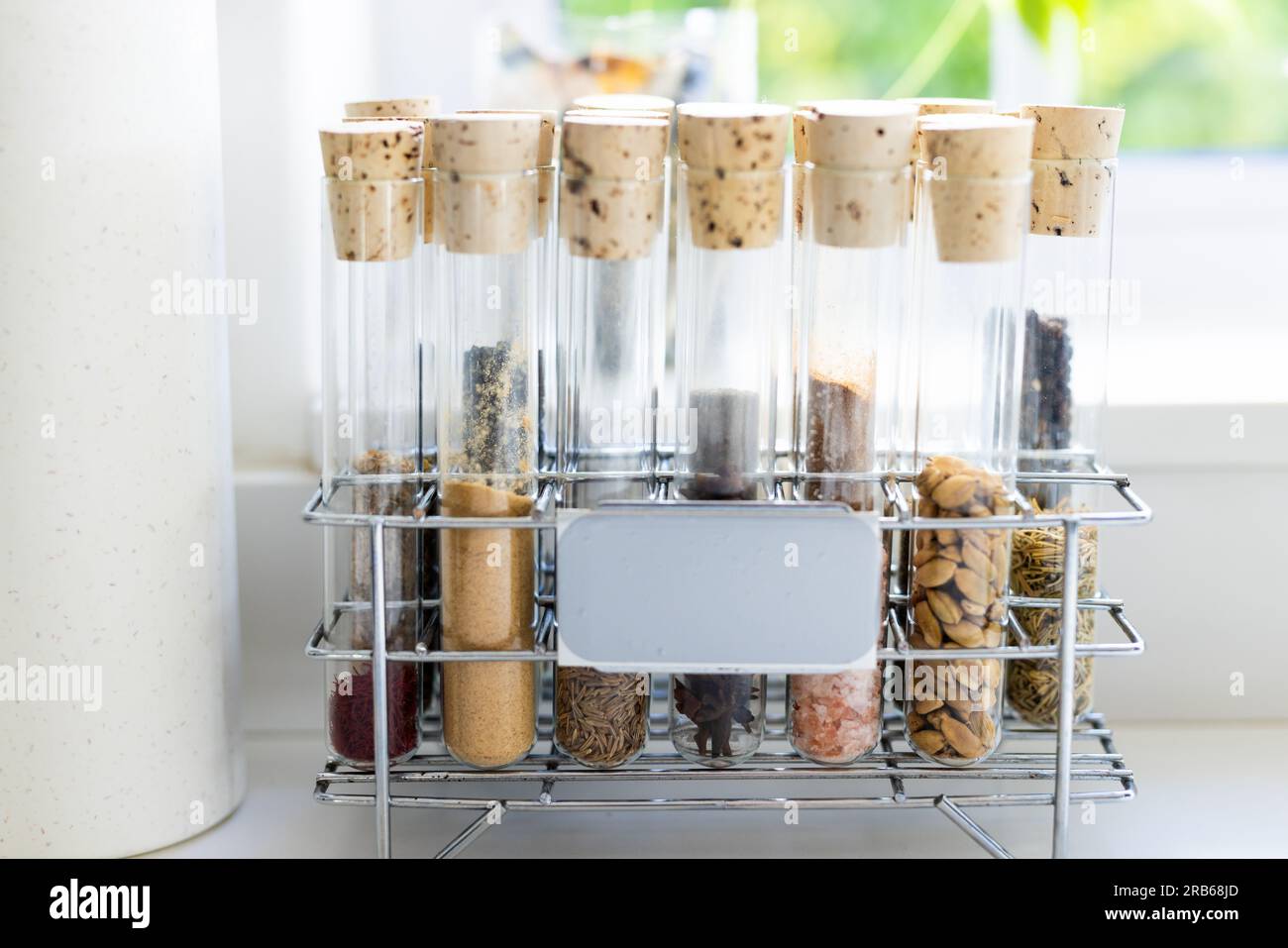 Close up of spices in tubes in rack on worktop in sunny kitchen ...
