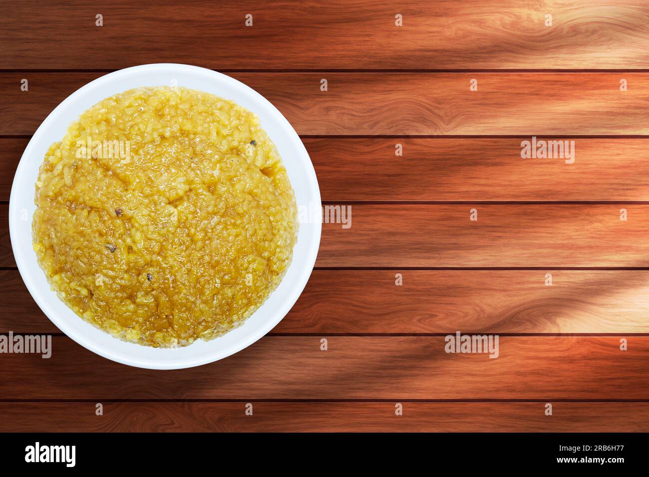 Traditional Indian food Pongal sweets in white bowl on wooden ...