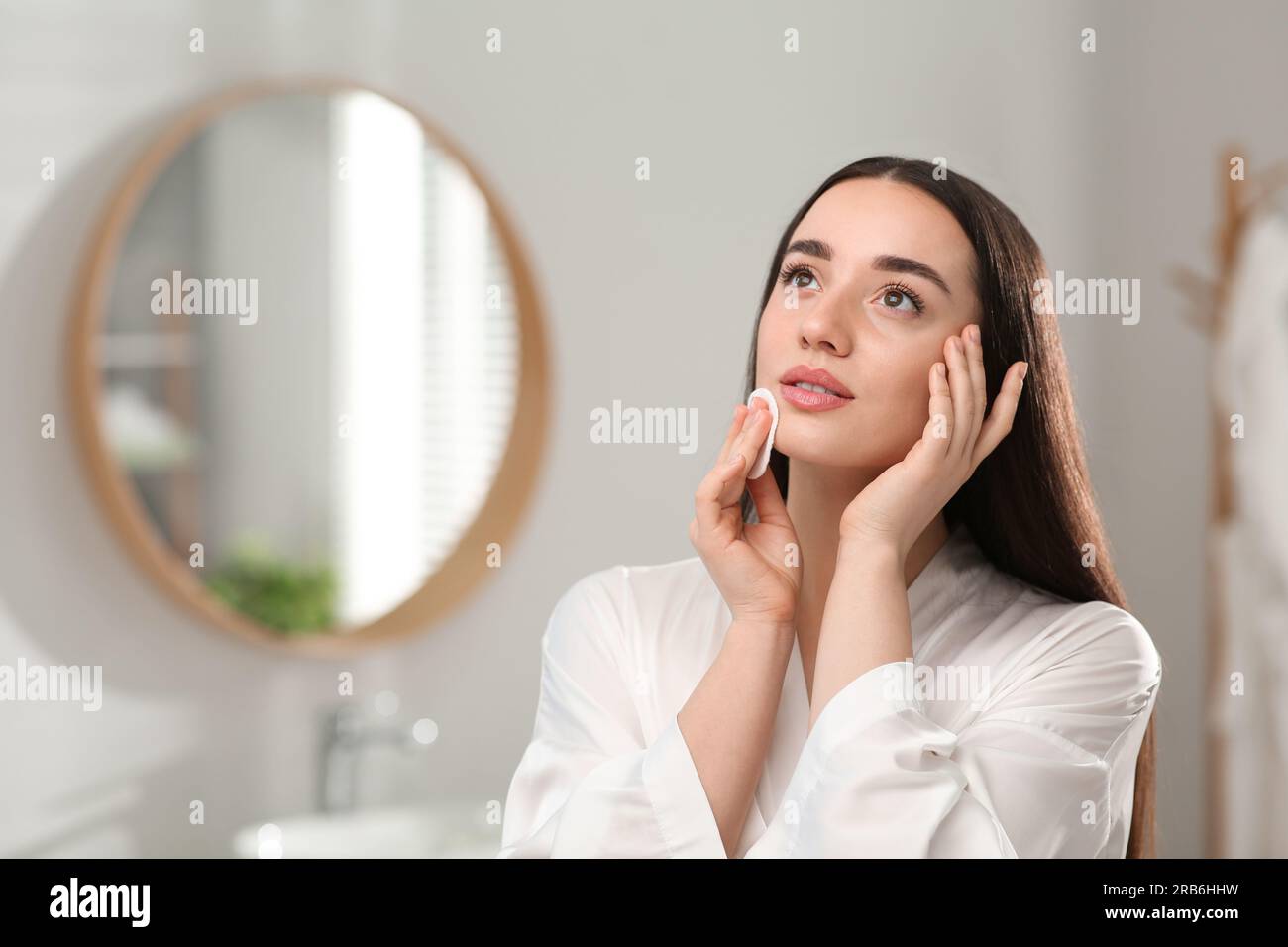 Beautiful woman removing makeup with cotton pad indoors Stock Photo - Alamy
