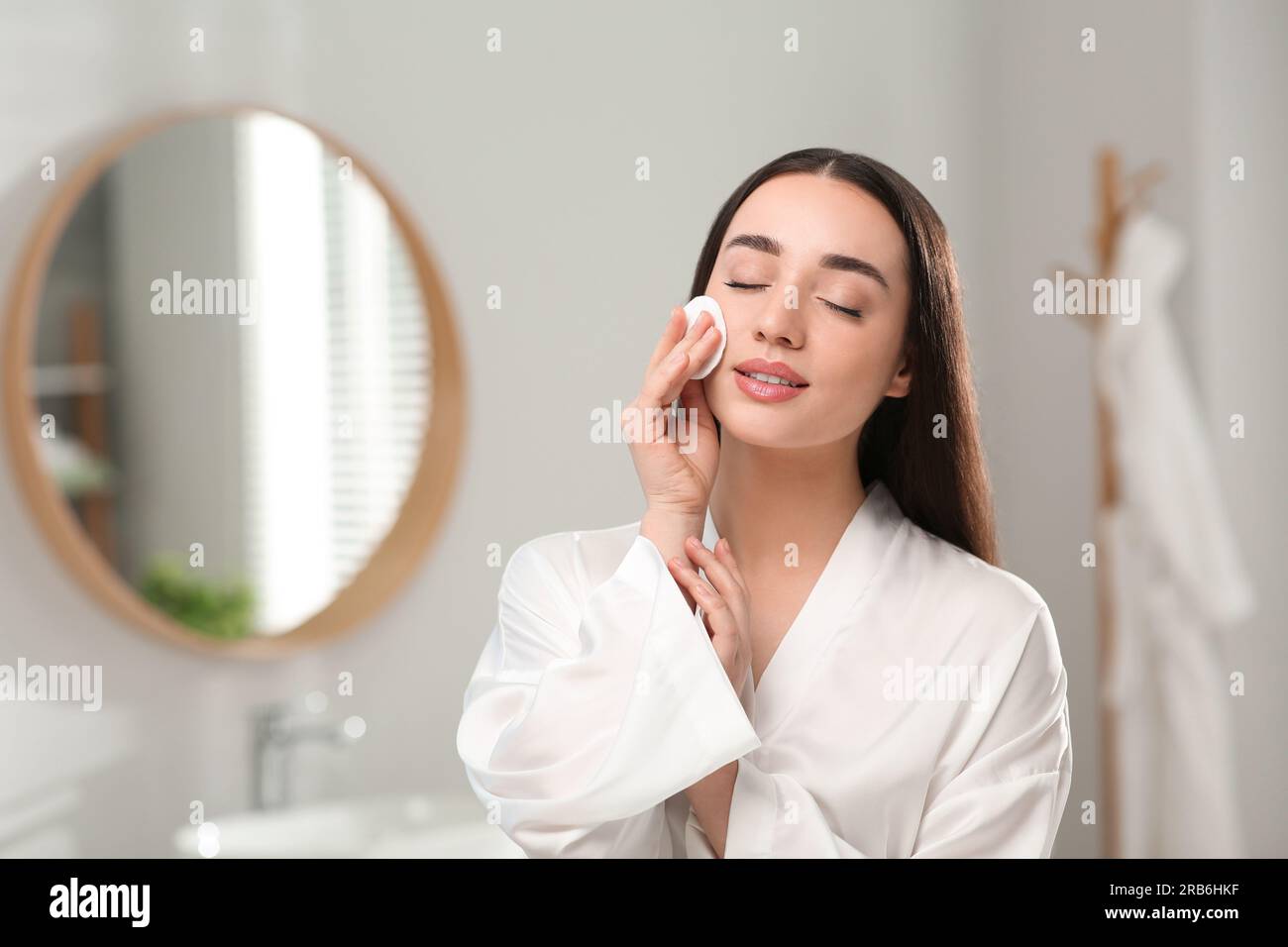 Beautiful woman removing makeup with cotton pad indoors Stock Photo - Alamy
