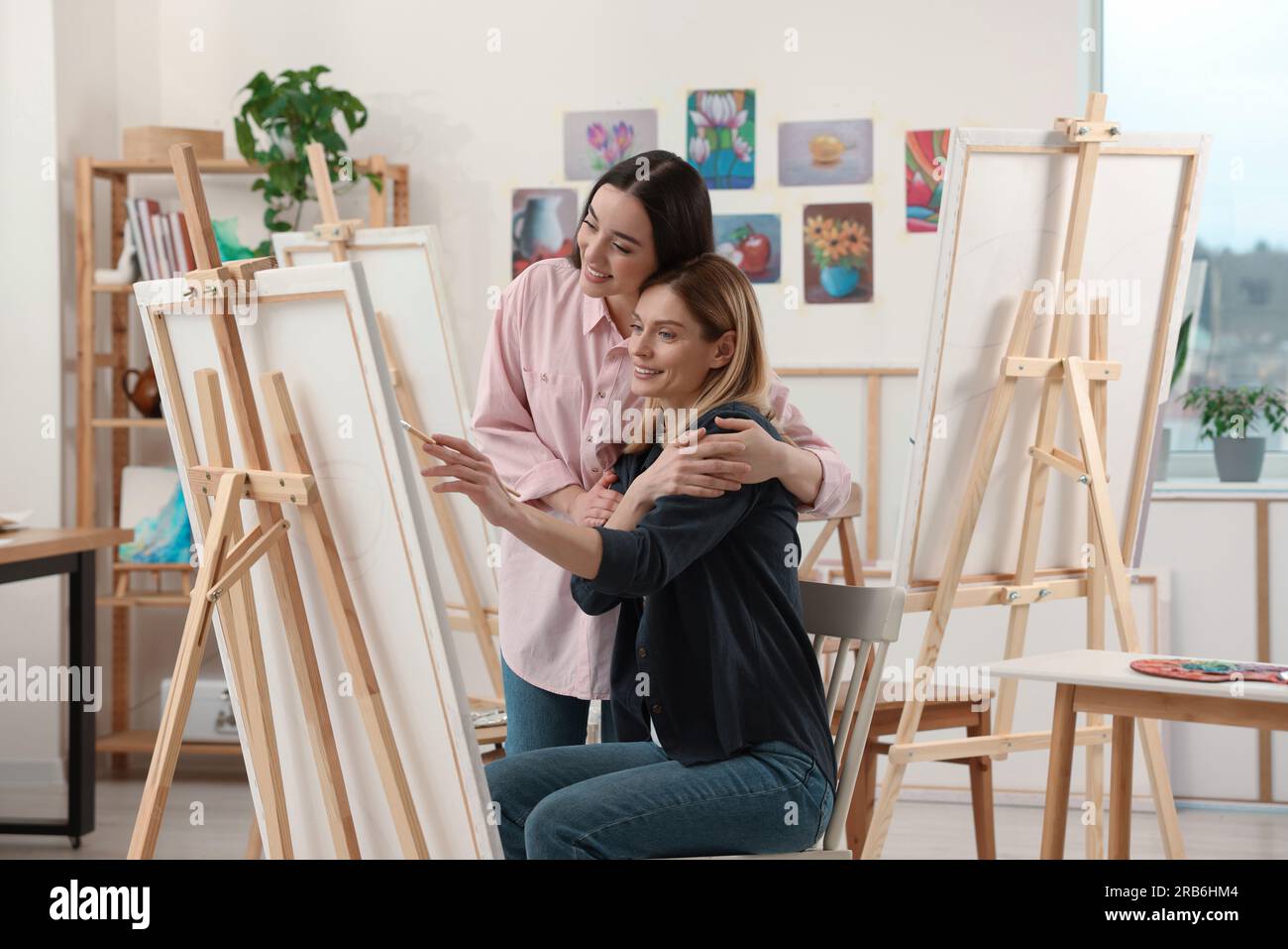 Artist teaching her student to paint in studio. Creative hobby Stock ...