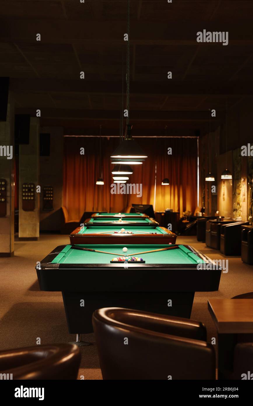 Billiard tables with balls and cues in club Stock Photo - Alamy