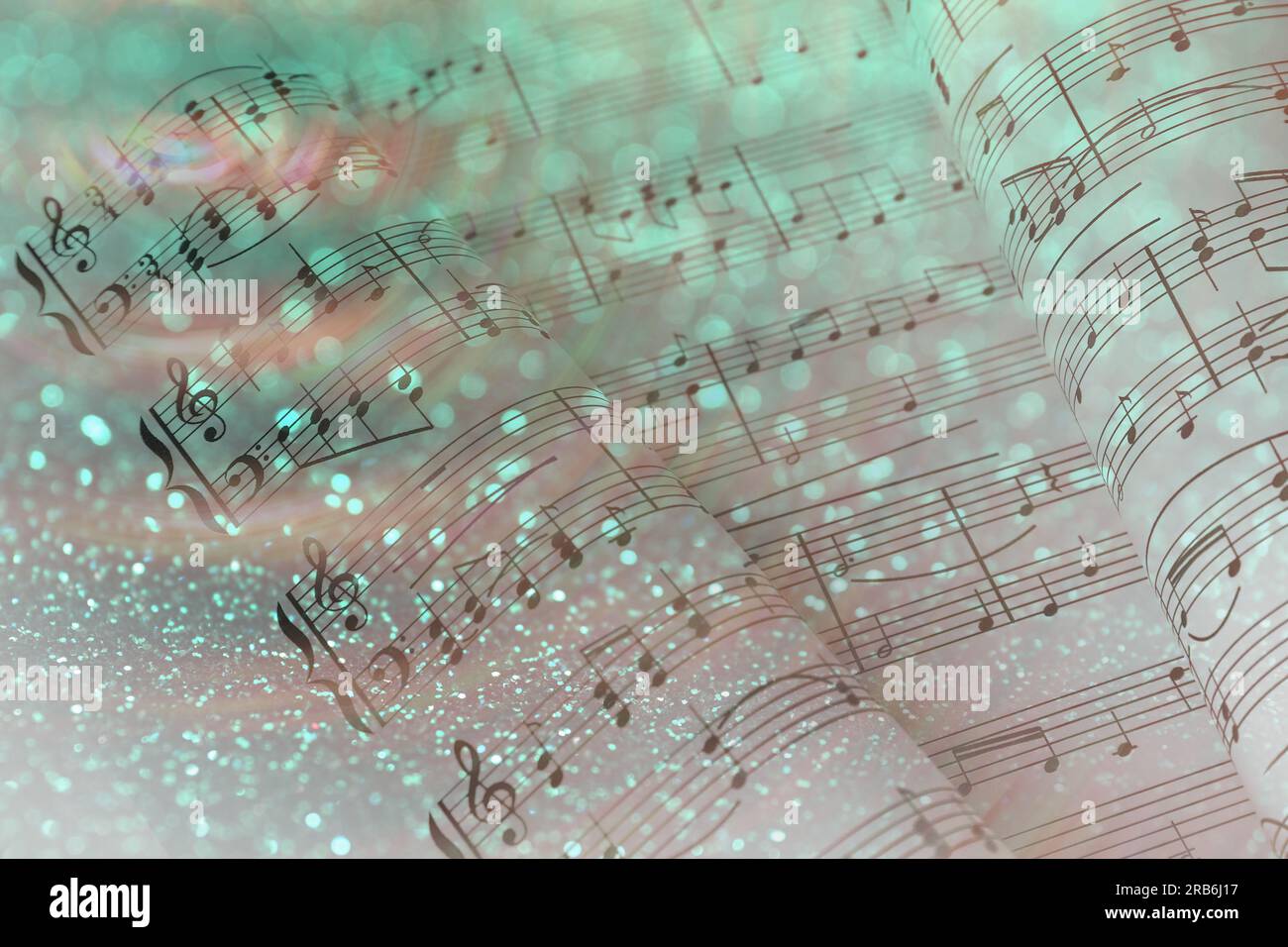 Double exposure of sheets with music notes and green glitter as ...