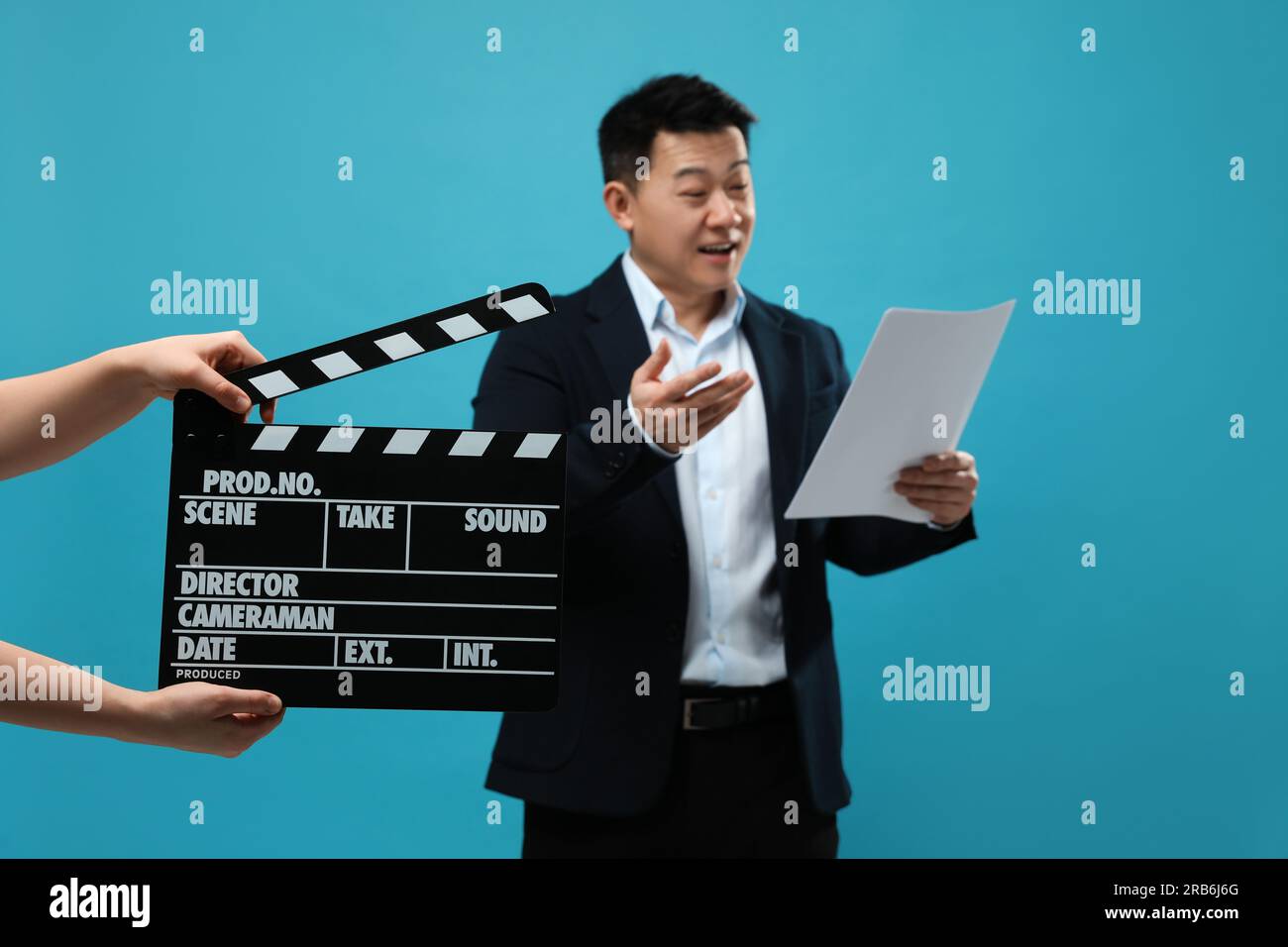 Happy asian actor performing role while second assistant camera holding ...