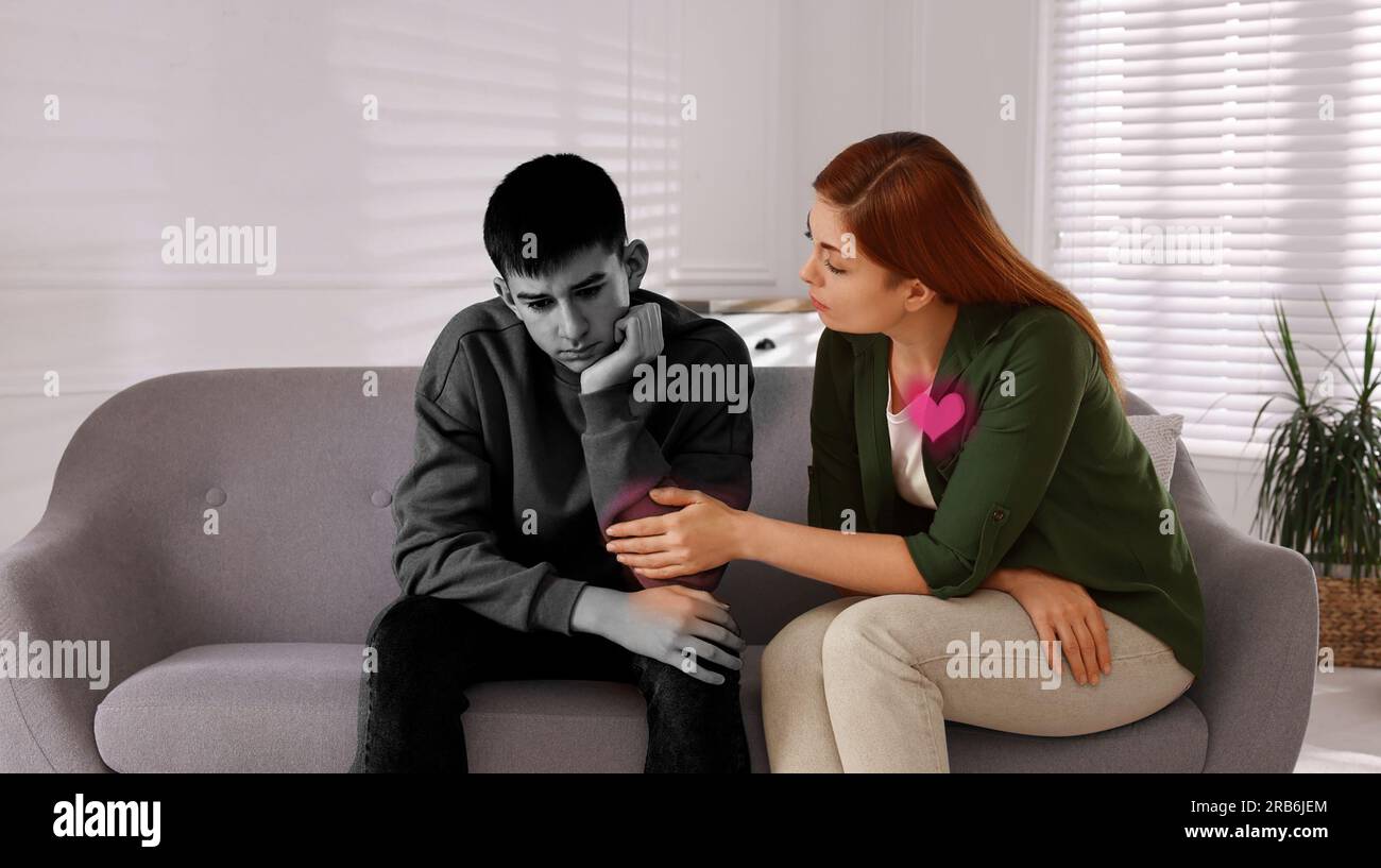 Mother talking with her teenage son indoors. Heart on her chest ...