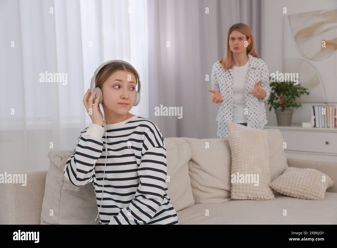 Teenage daughter with headphones ignoring her mother at home Stock Photo - Alamy