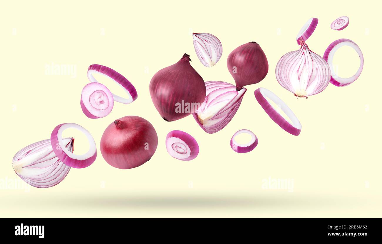Whole and cut fresh red onions falling on beige background Stock Photo ...
