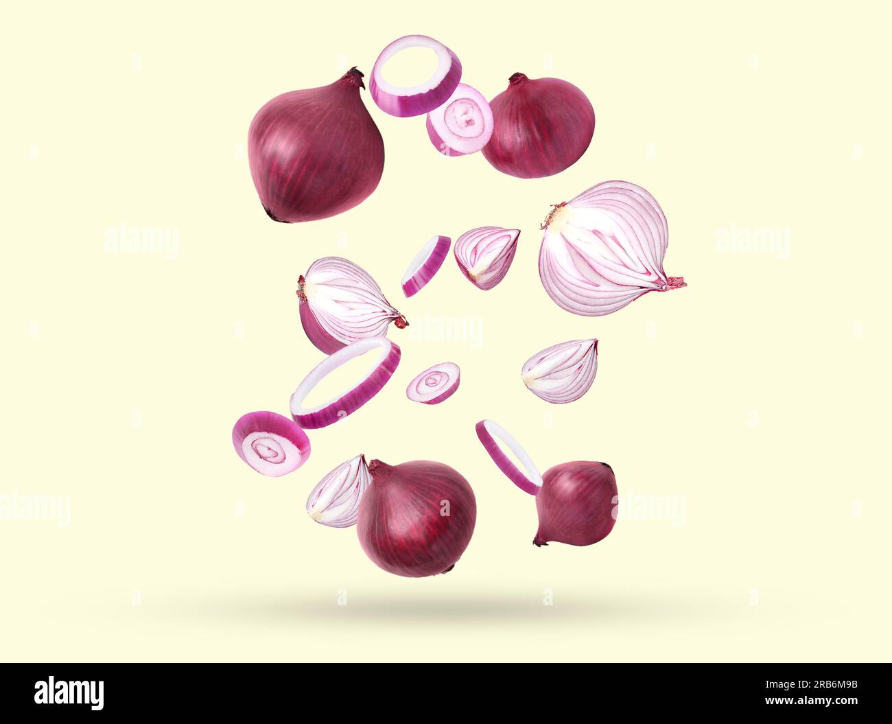Whole and cut fresh red onions falling on beige background Stock Photo ...