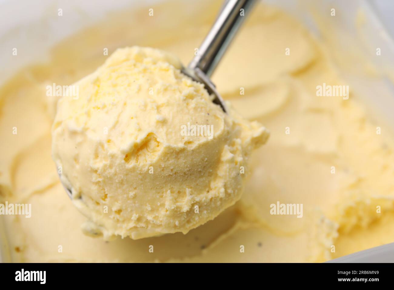 Taking scoop of vanilla ice cream from container, closeup Stock Photo ...