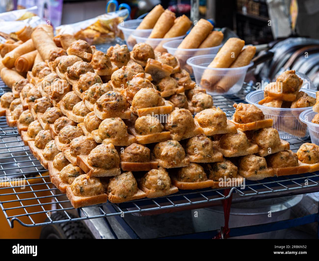 Fried bread with minced pork spread for sale at a local street food market in Bangkok, Thailand ...