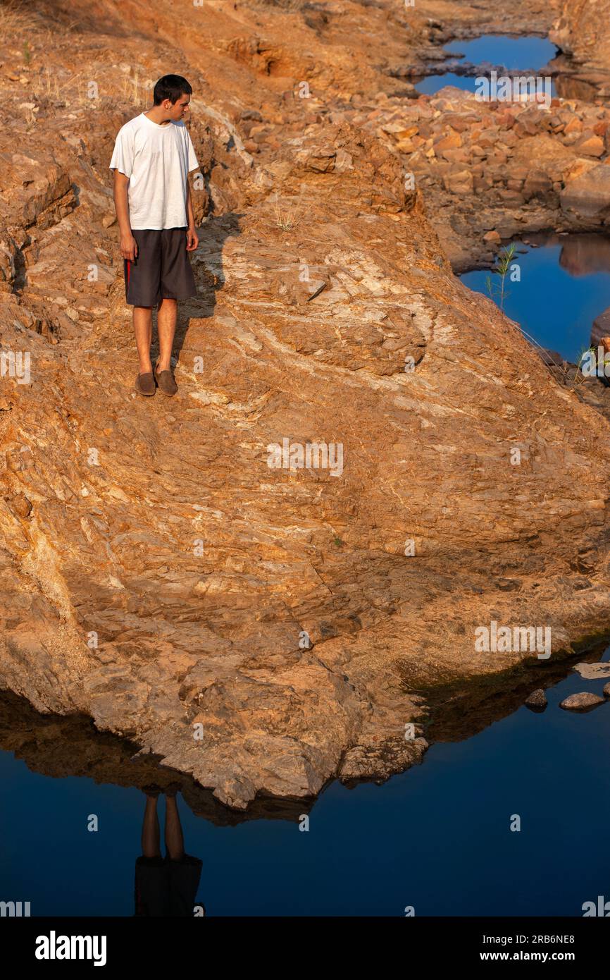 teenager exploring african landscape eroded red granite rock by the ...